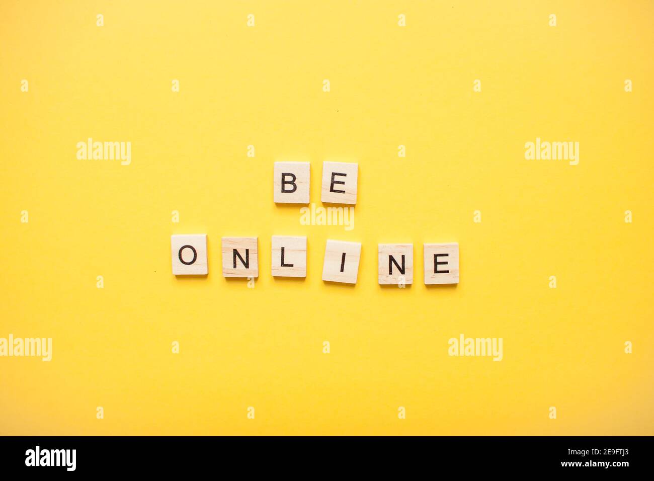 Phrase be online made from wooden blocks on a light yellow background ...