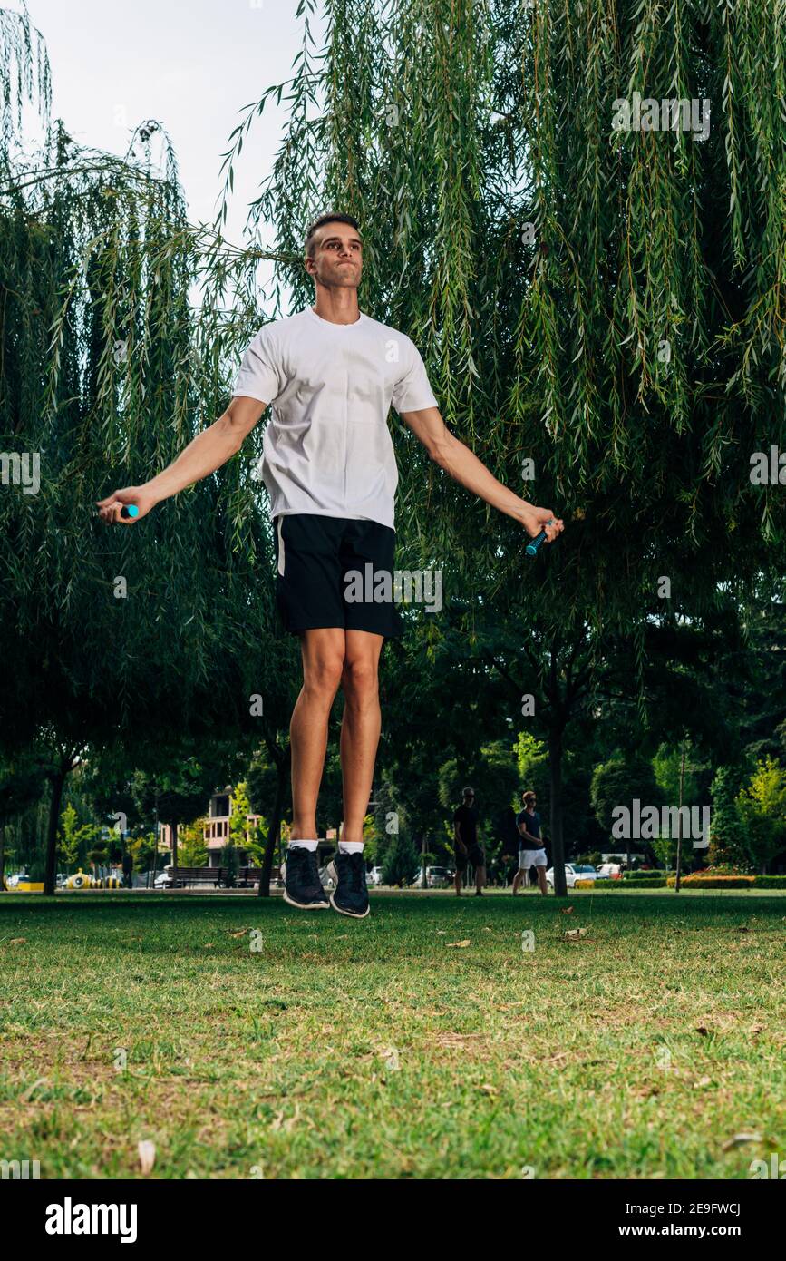 Fitness, sport, people, exercising and lifestyle concept - man skipping ...