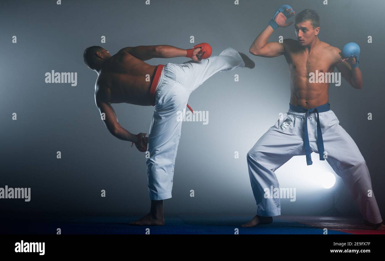 Strong fit athlete, karate man or fighter in white kimono, suit, with ...