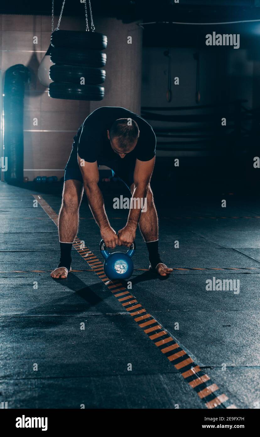Handsome bodybuilder pumping up muscular body, doing exercises in gym ...