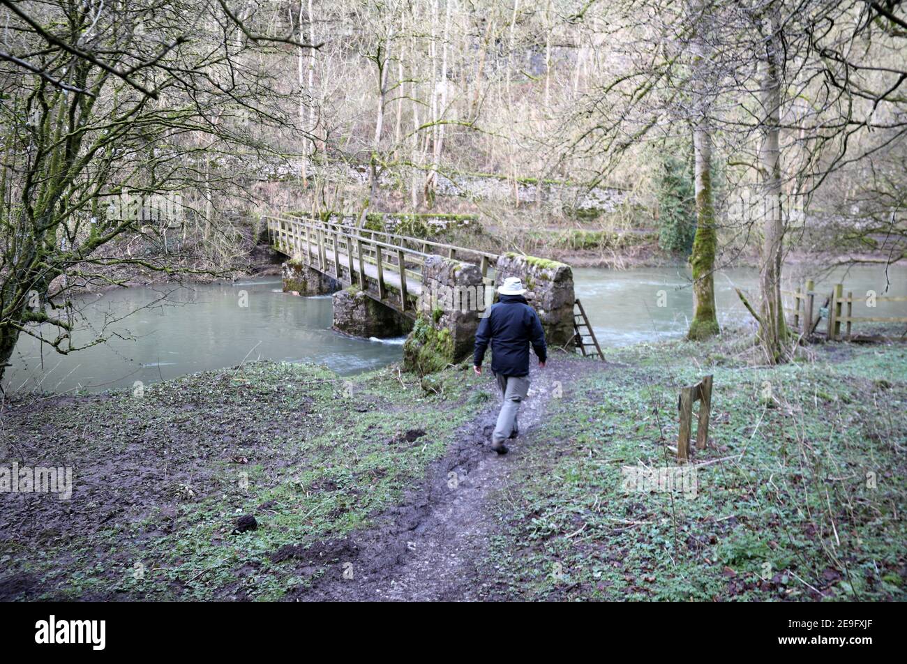 Walker about to cross the footbridge at Litton Mill in Derbyshire Stock ...