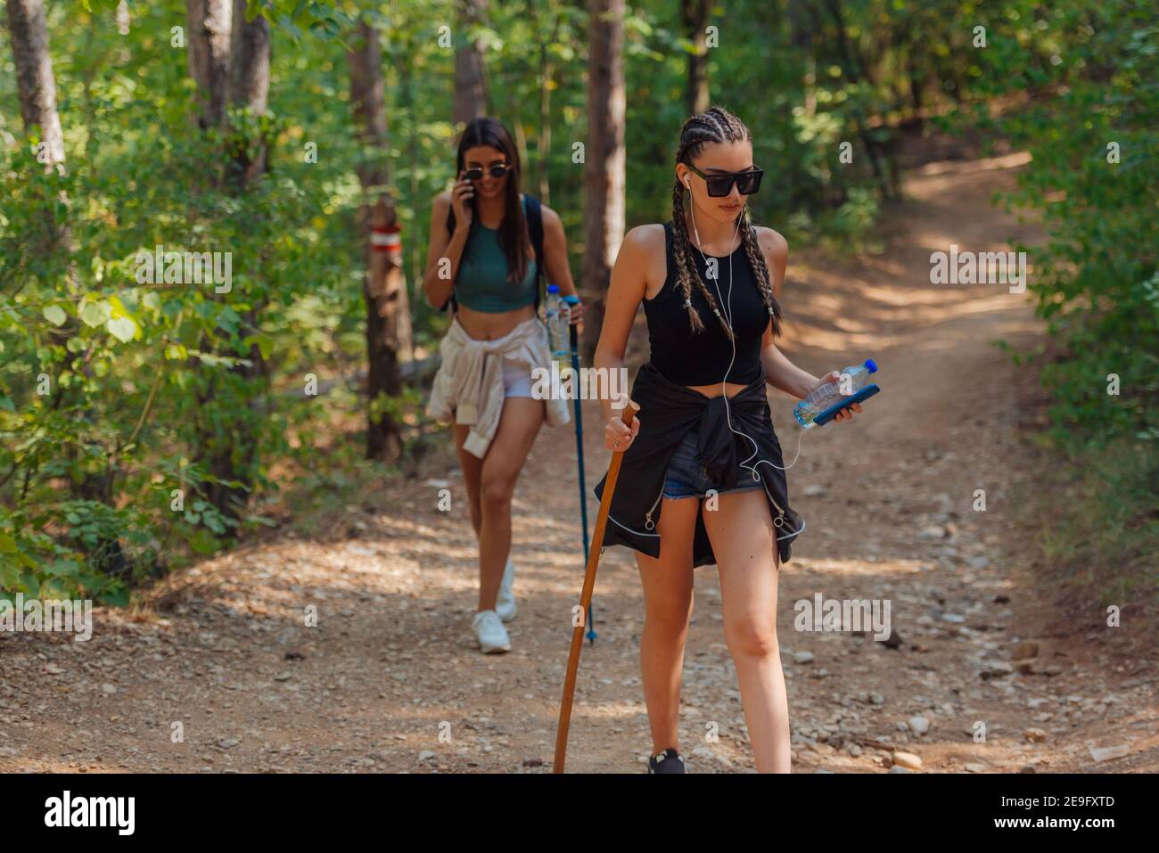 Sisters hiking through beautiful woods while wearing a backpack and ...