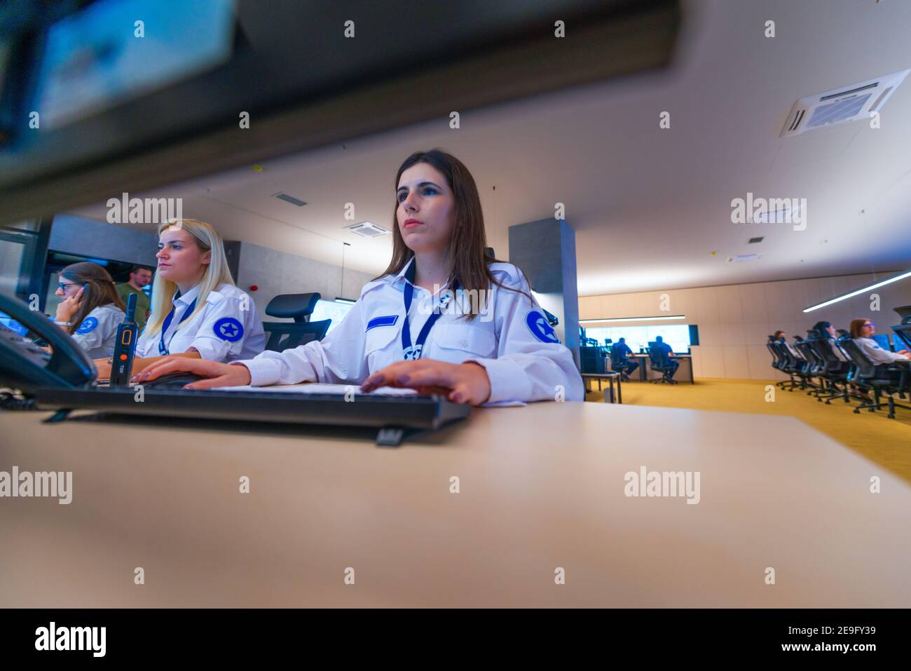 Female security operator working in a security data control room ...