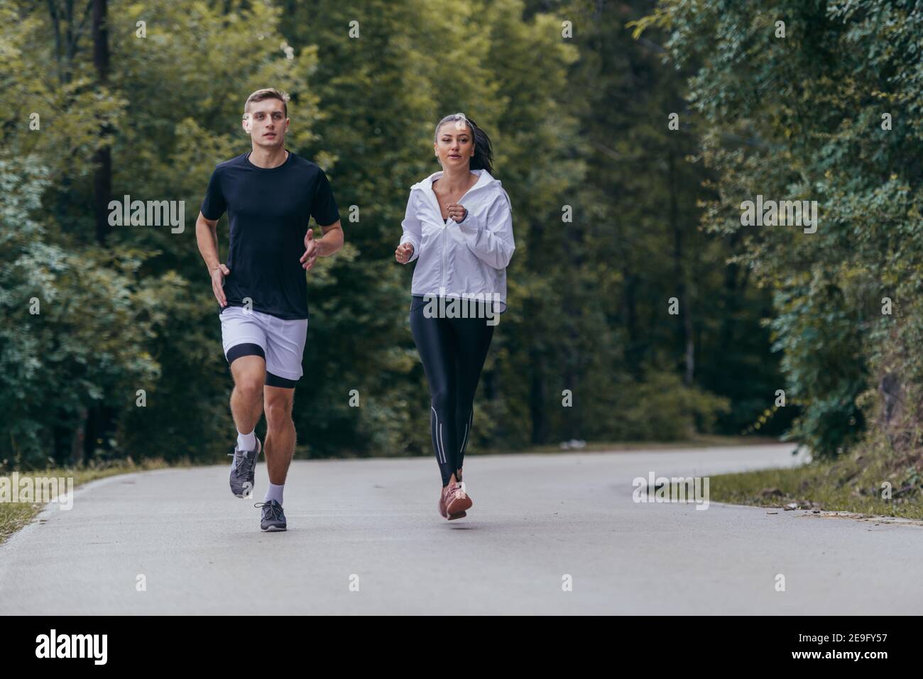 Athletic couple running on a street next to each other. Nature,fit and ...