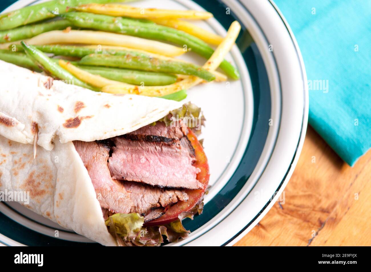 flank steak burrito on home made flatbread with garlic fried str Stock ...