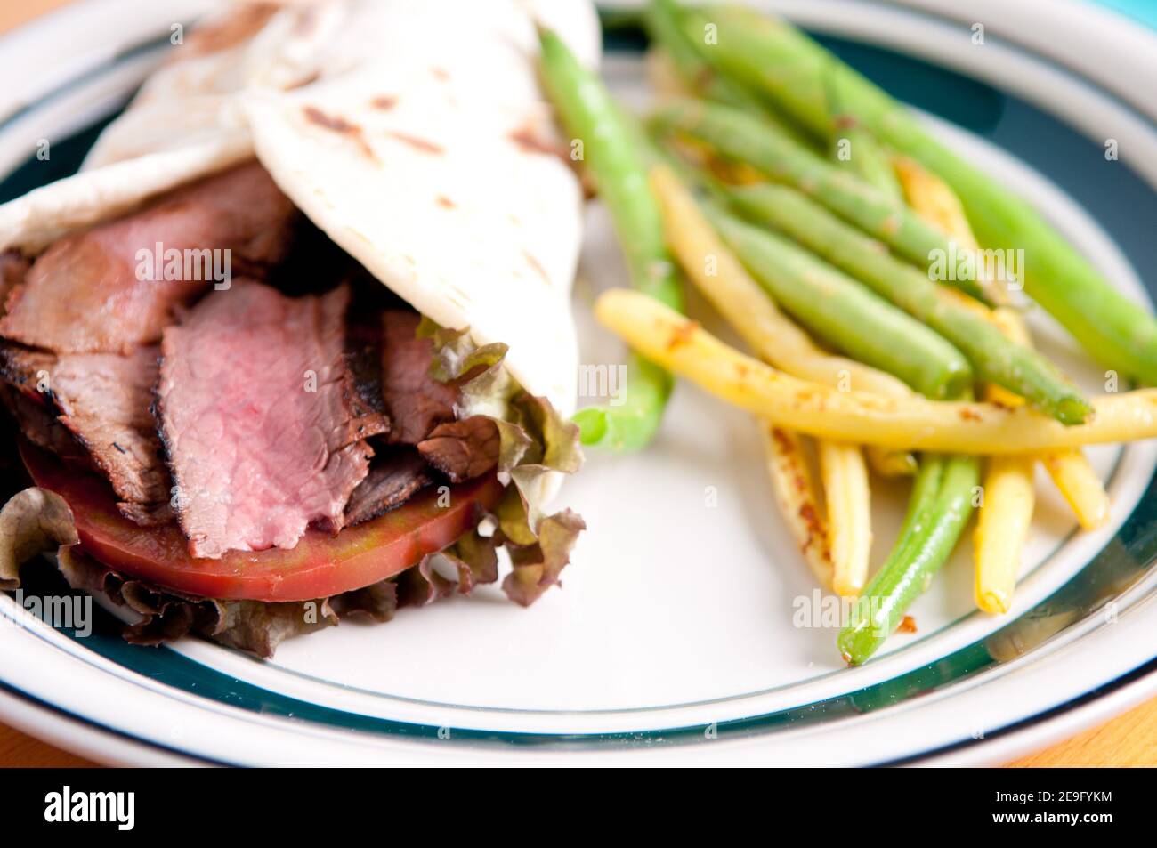 flank steak burrito on home made flatbread with garlic fried str Stock ...