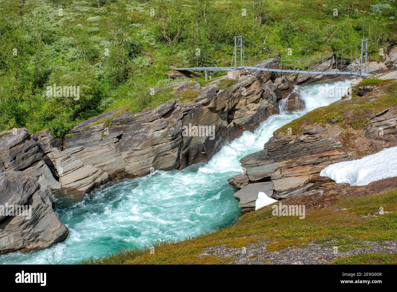 Suspension Bridge in the Mountains over fast flowing turbulent river ...