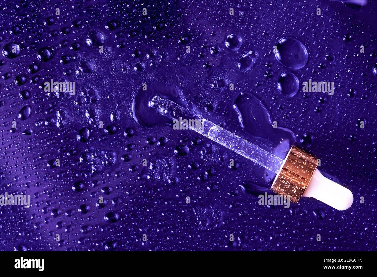 Purple background with liquid splashed and medicine dropper Stock Photo ...