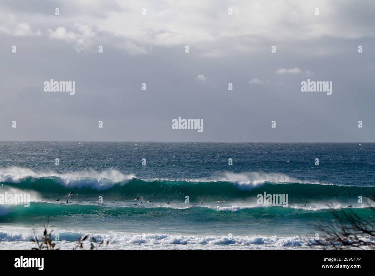 Surfers facing a huge wave Stock Photo - Alamy