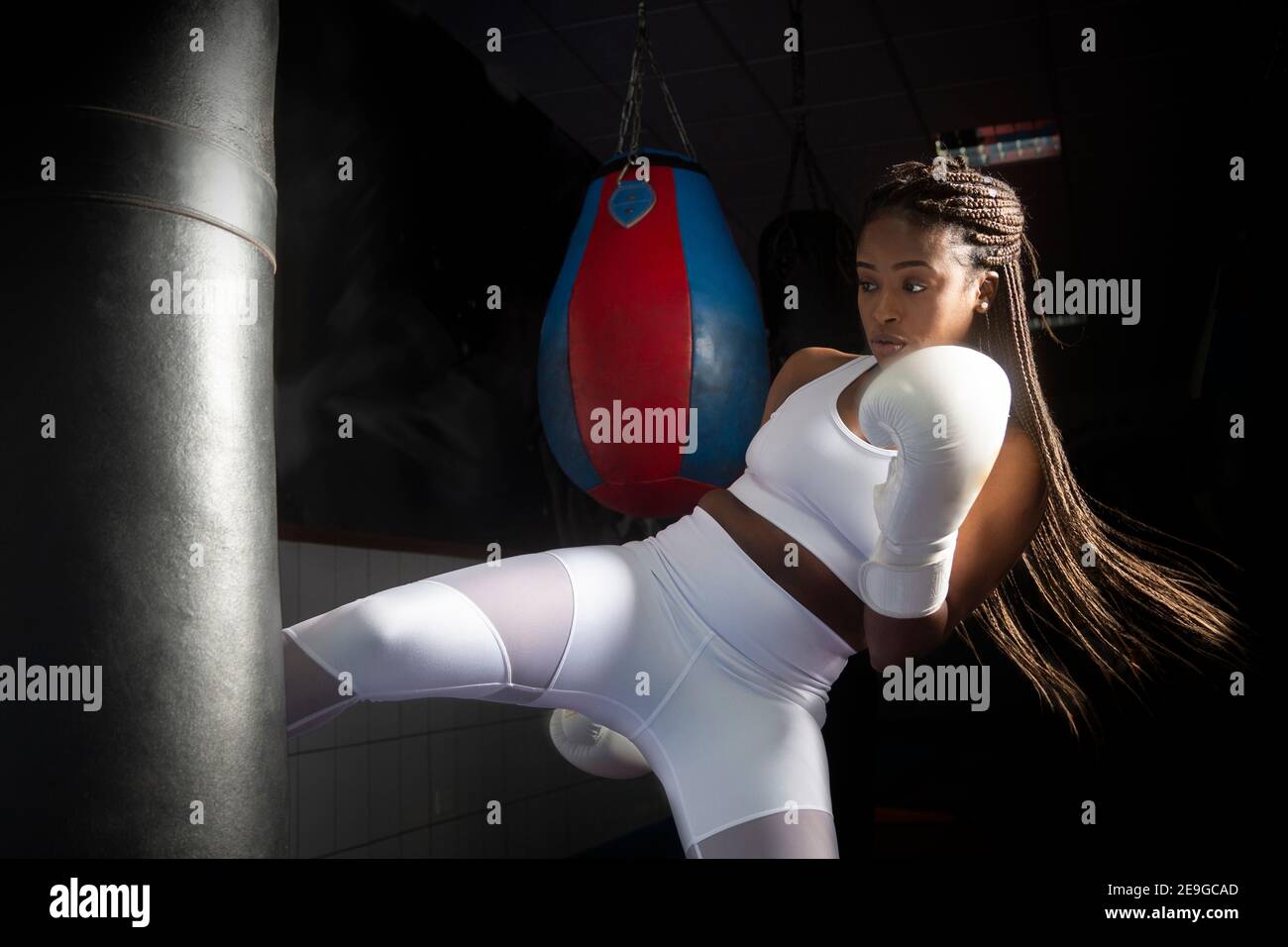 Young afro girl training kickboxing inside the gym, strength ...