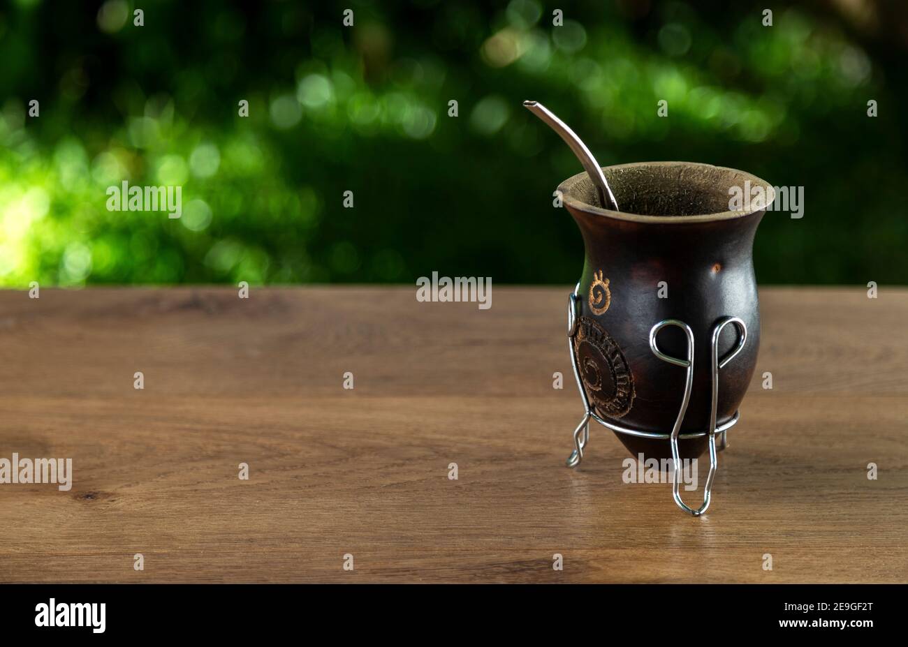 Traditional mate made of calabash over a wooden table outdoors. Copy ...