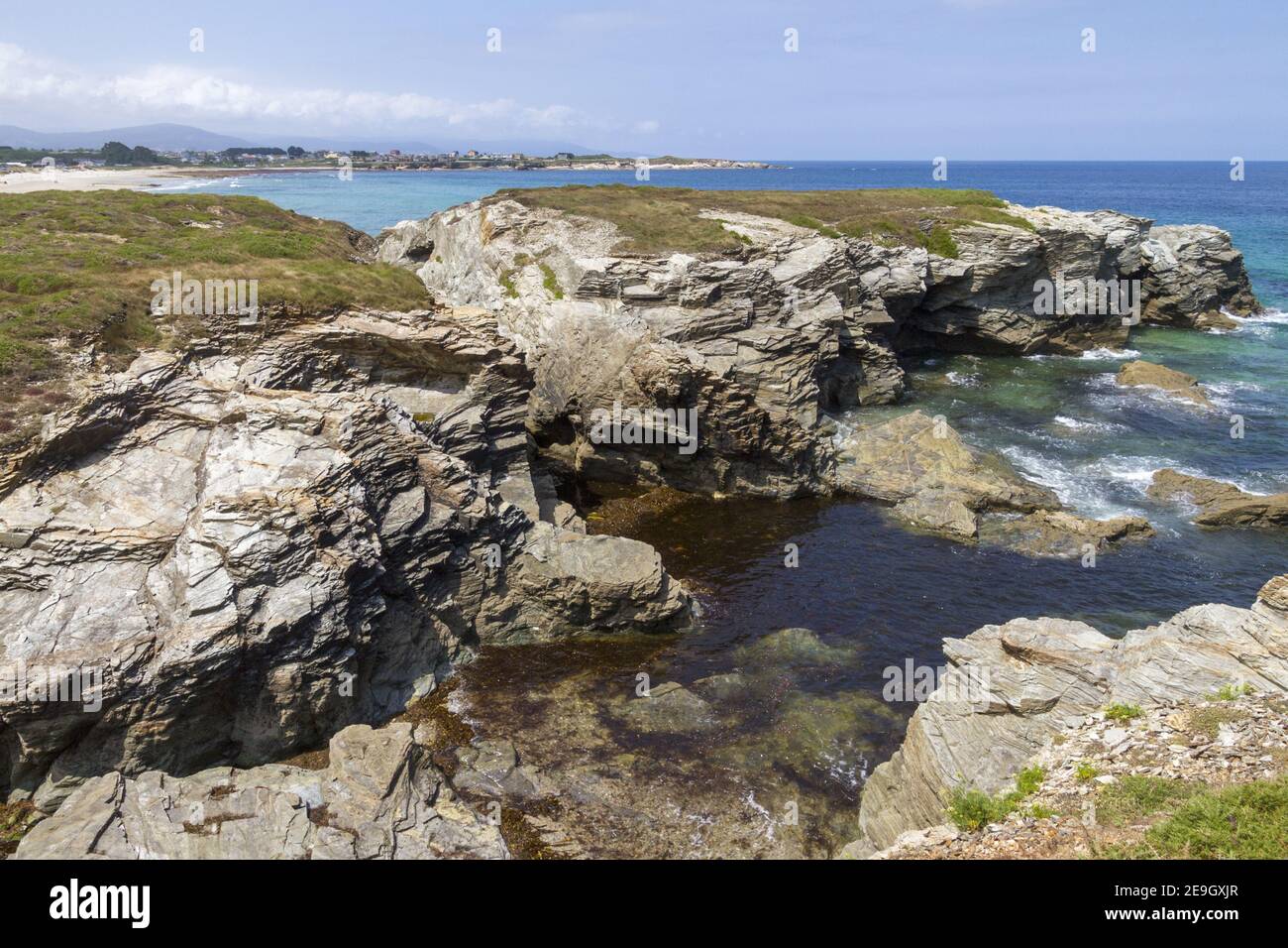 Stone shore at the beach washed by blue ocean waves Stock Photo - Alamy