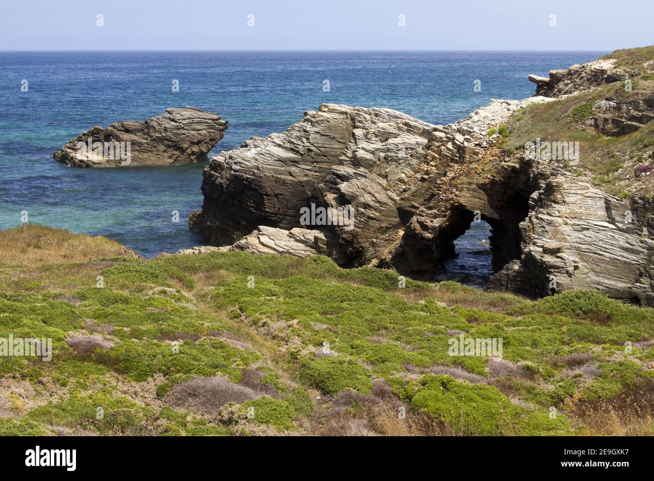 Stone shore at the beach washed by blue ocean waves Stock Photo - Alamy