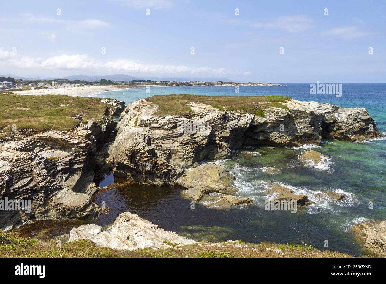 Stone shore at the beach washed by blue ocean waves Stock Photo - Alamy