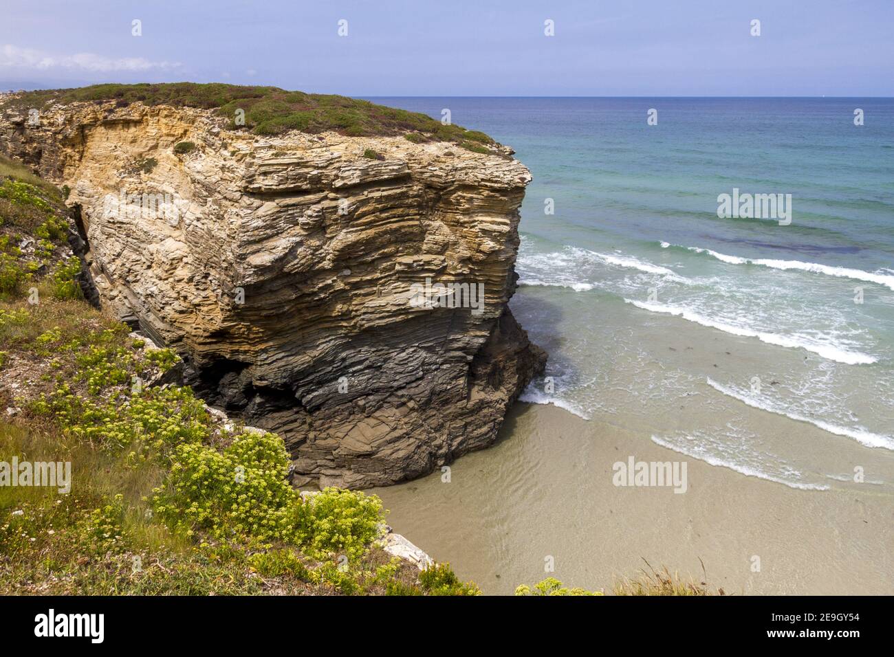 Big rock at the beach washed by blue ocean waves Stock Photo - Alamy