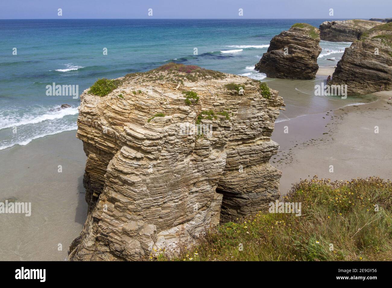 Big rock at the beach washed by blue ocean waves Stock Photo - Alamy