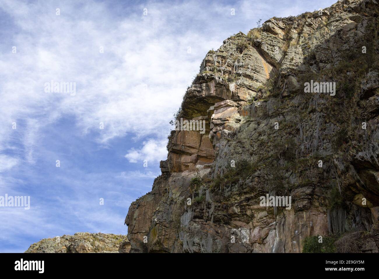 Low angle of a rocky cliff against a wispy sky background Stock Photo ...