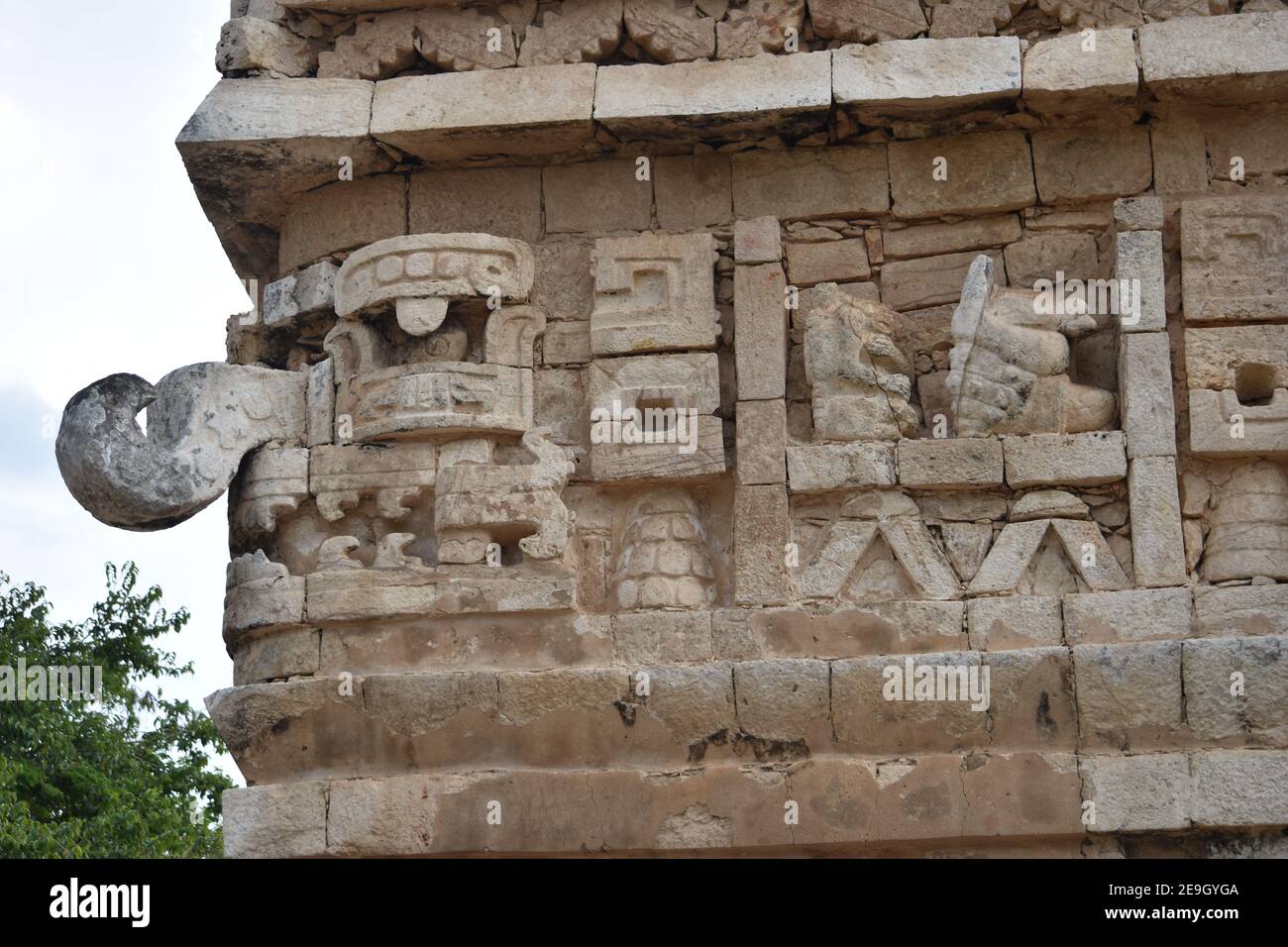 Stone sculpture of rain god Chac with curly nose on the corner of ...