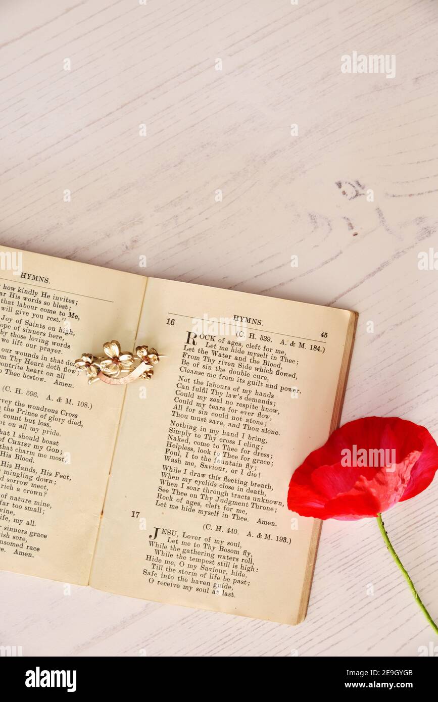 Poppy and brooch showing Ypres on top of open First World War prayer ...