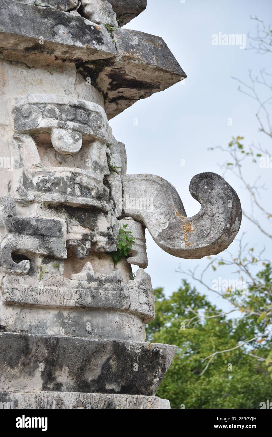 Stone sculpture of rain god Chaac with curly nose on the corner of ...
