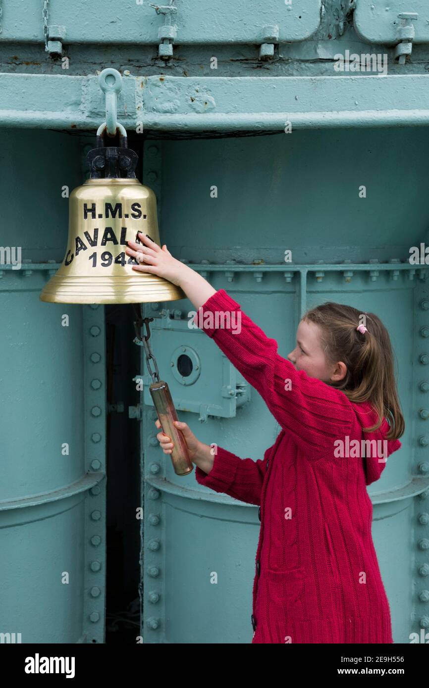 Eight year old girl tourist visitor child / kid ringing the ship bell ...