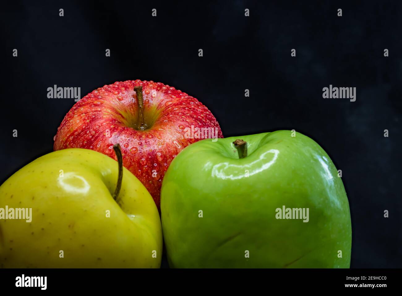 Red, yellow, and green apples isolated on a black background Stock ...