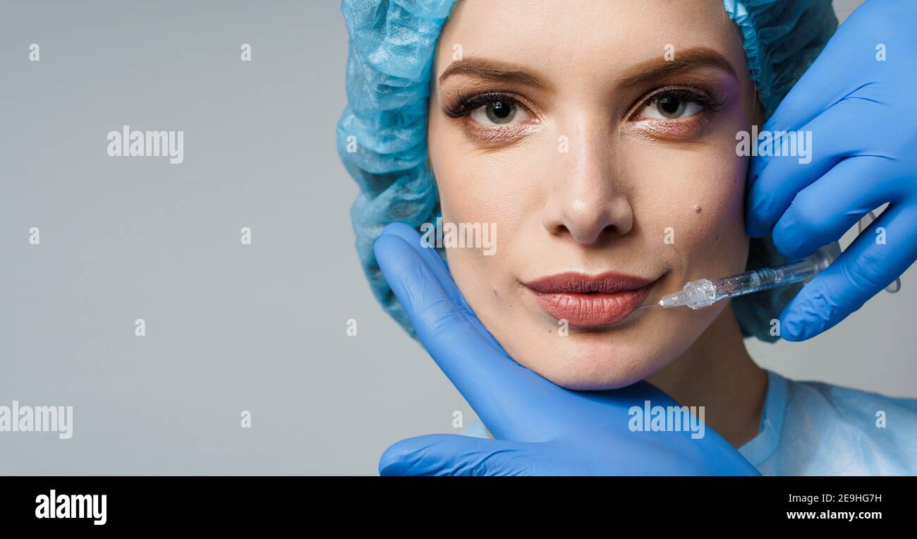 Closeup lips augmentation injections for attractive girl on white ...