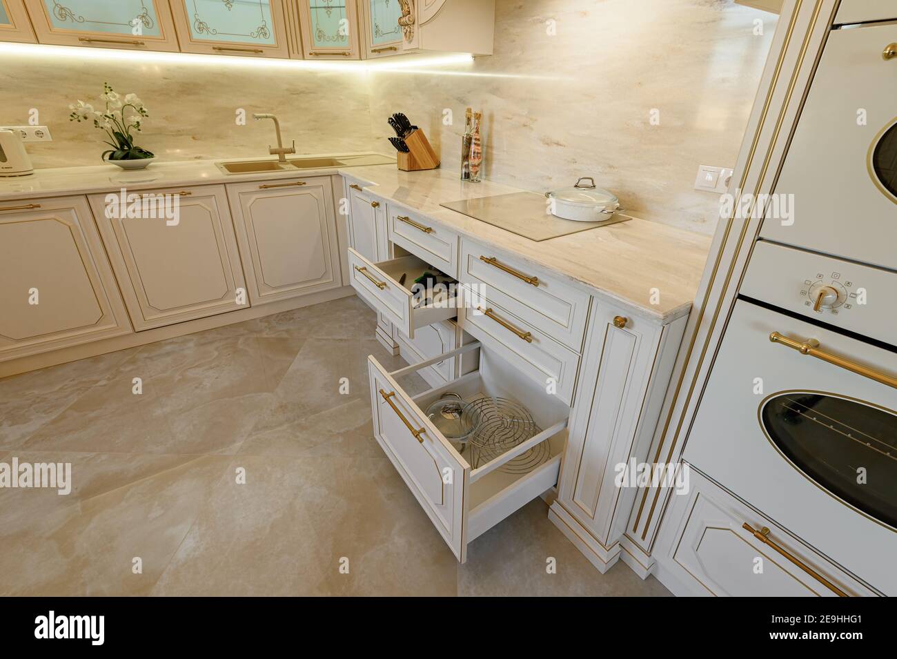 Open drawer in cabinet at luxury beige and gold classic kitchen ...