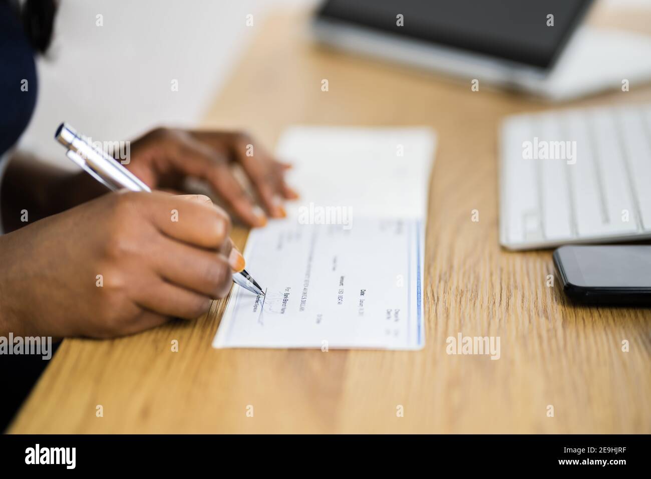 African Woman Signing Bank Check Or Paycheck Stock Photo - Alamy