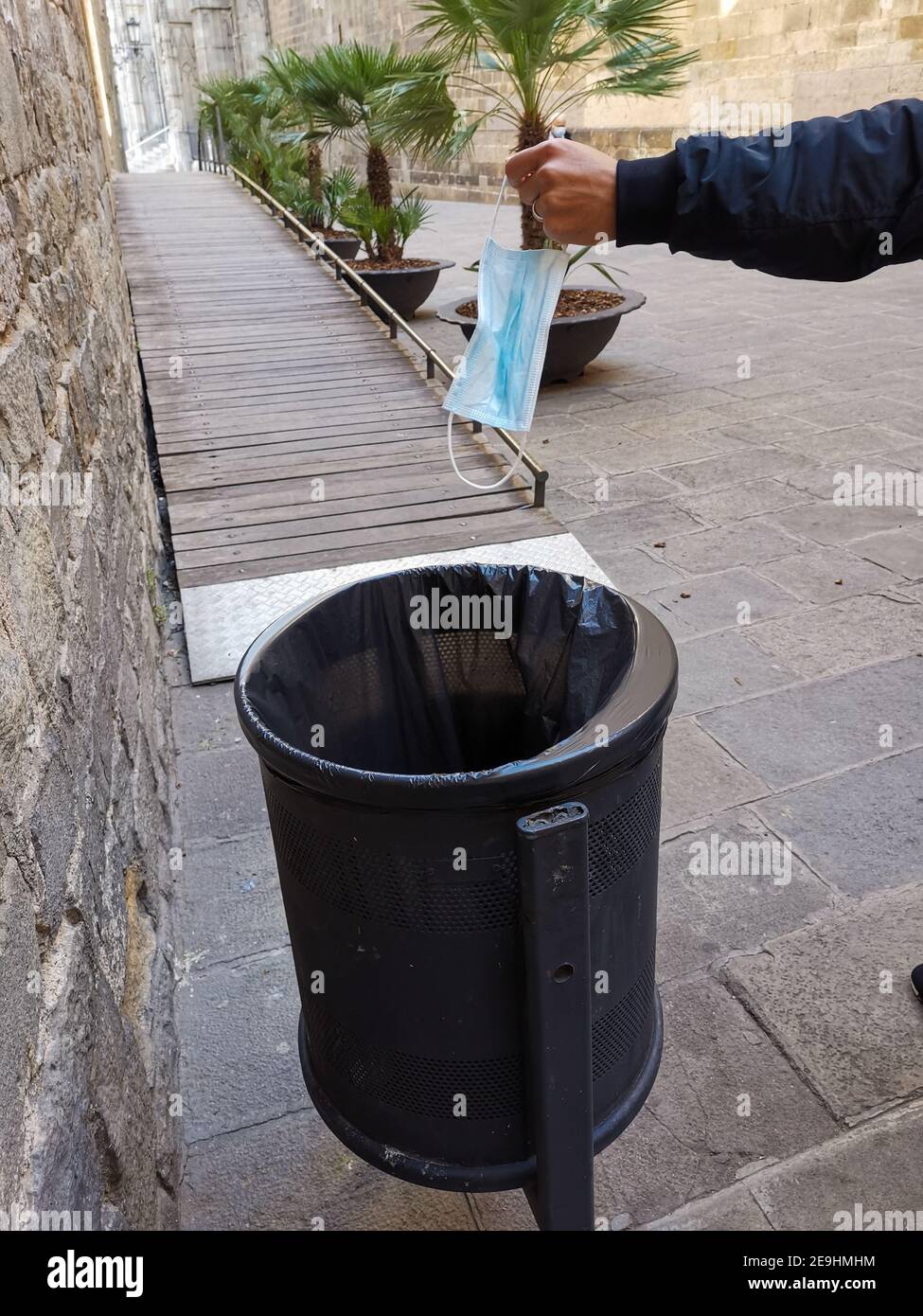 Vertical shot of a person throwing a face mask in the trash Stock Photo ...