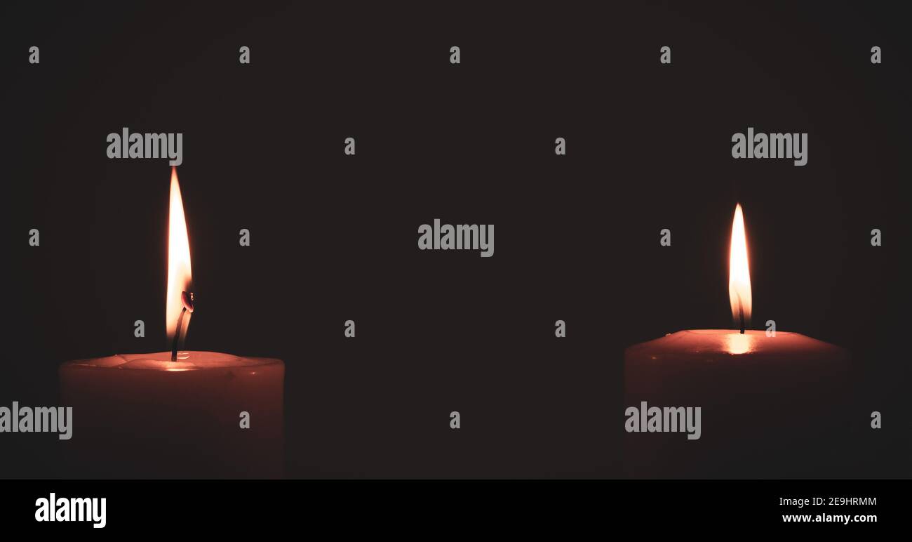 two candles burning in dark Stock Photo - Alamy