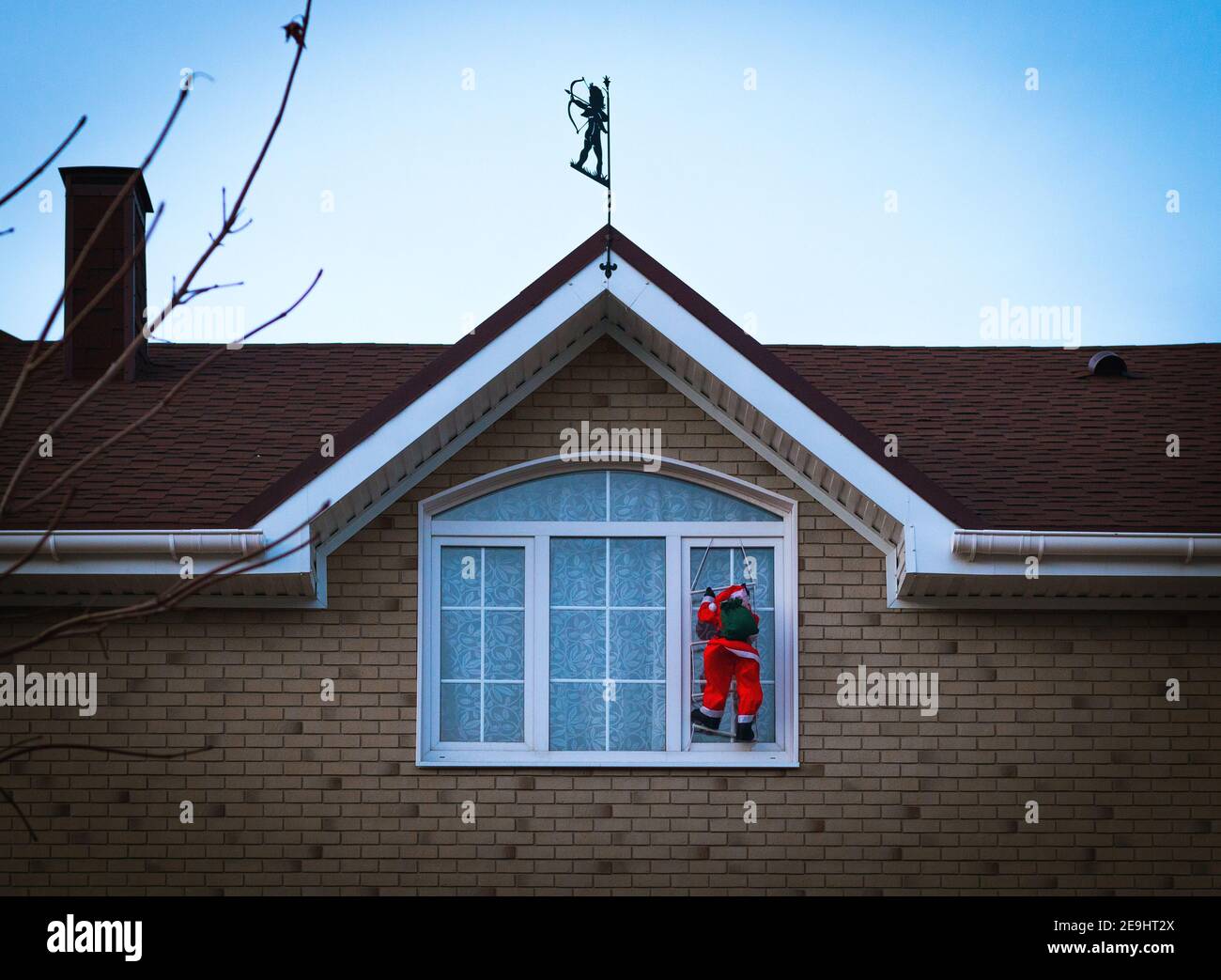 big toy Santa Claus gets in window Stock Photo - Alamy