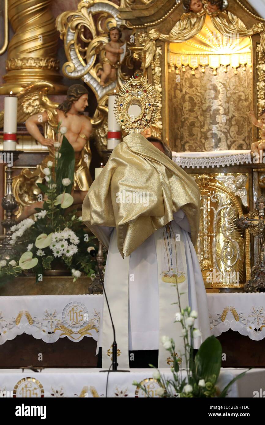 The priest holds the Blessed Sacrament in his hands during the ...