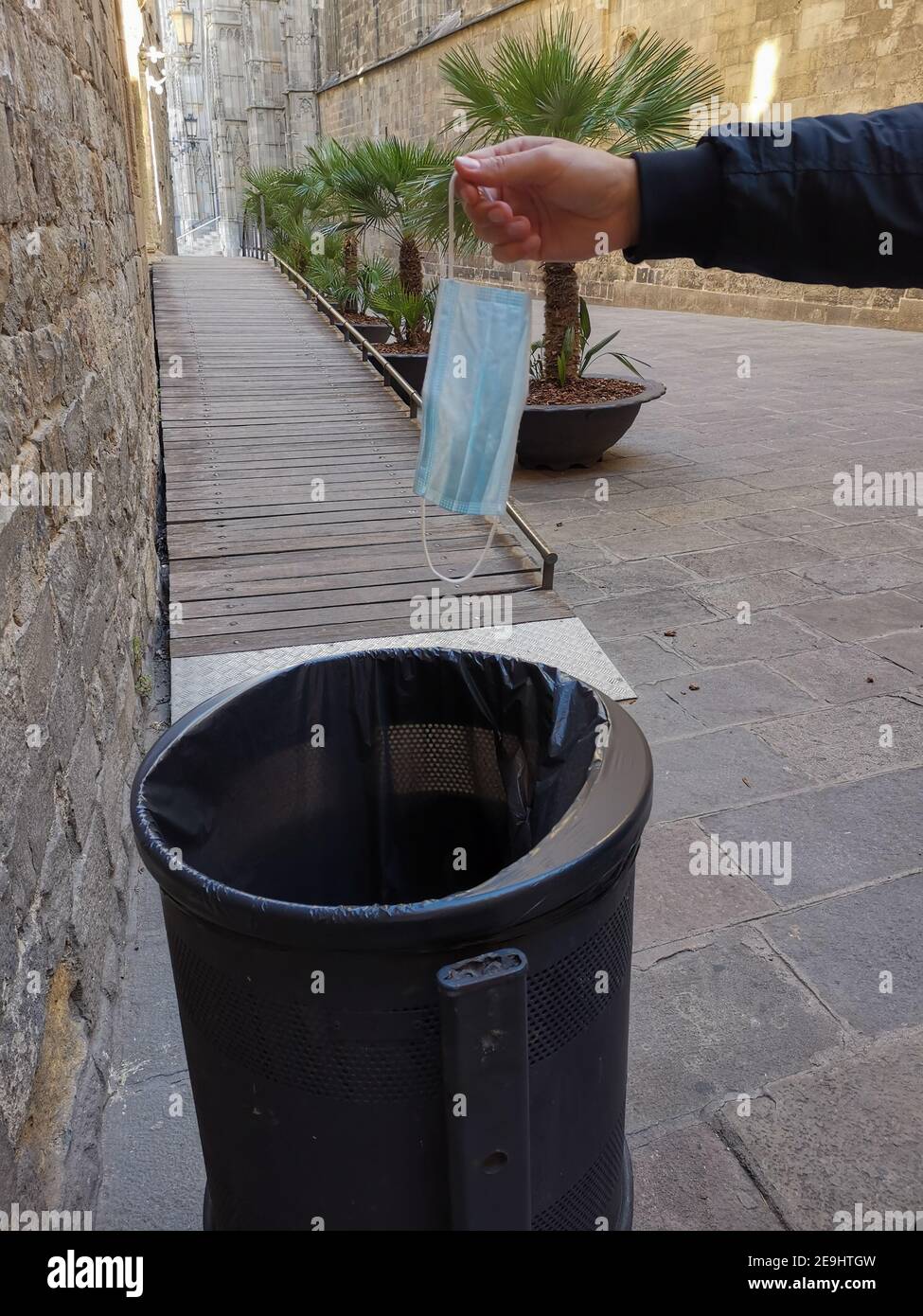 Vertical shot of a person throwing a face mask in the trash Stock Photo ...