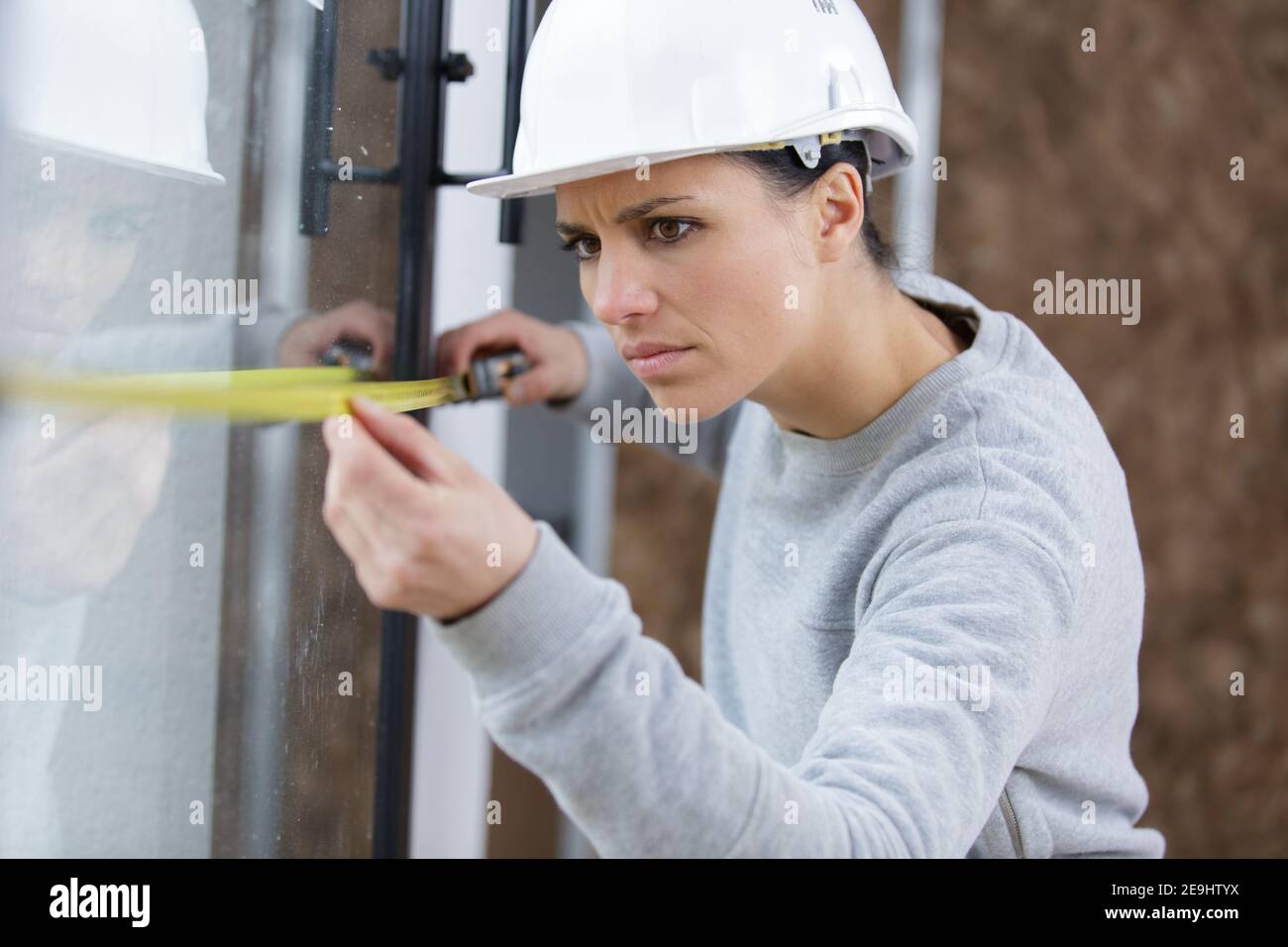 extended tape measure held by professional woman Stock Photo - Alamy