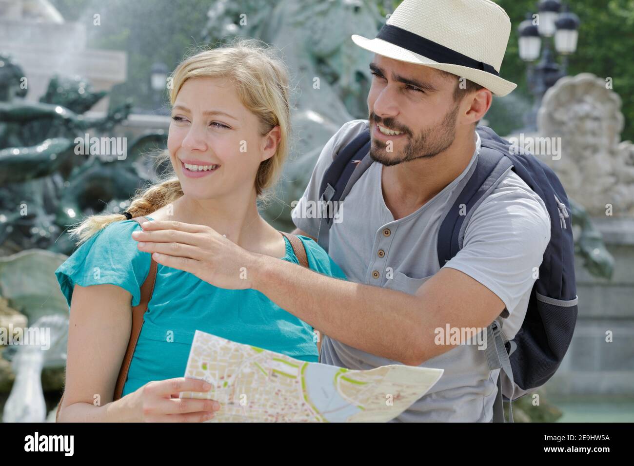 tourist couple in marina looking up directions on map Stock Photo - Alamy