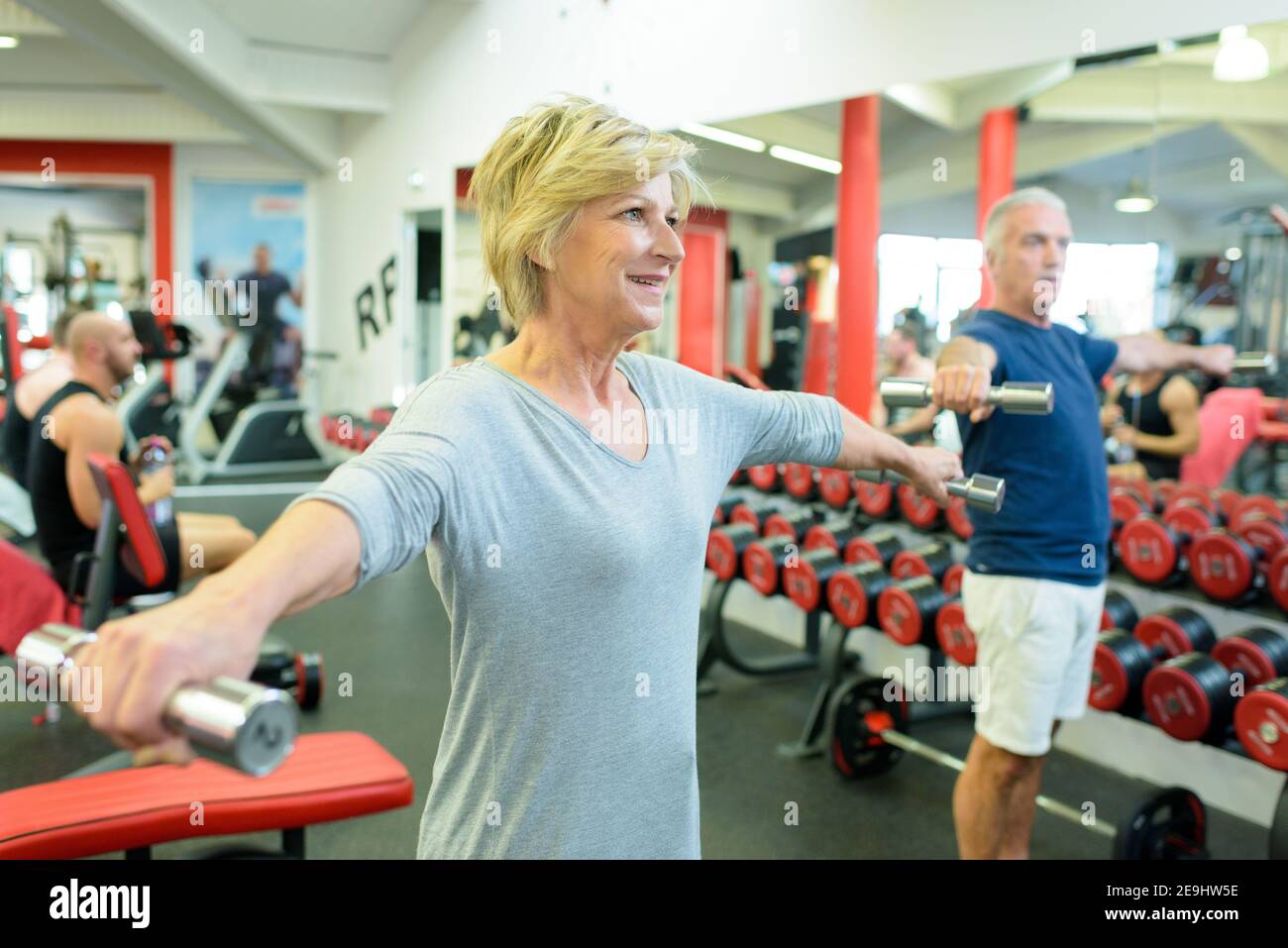 senior couple using weights in the gym Stock Photo - Alamy