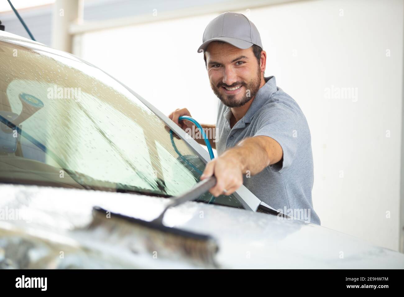 portrait of confident male worker washing red car at garage Stock Photo ...
