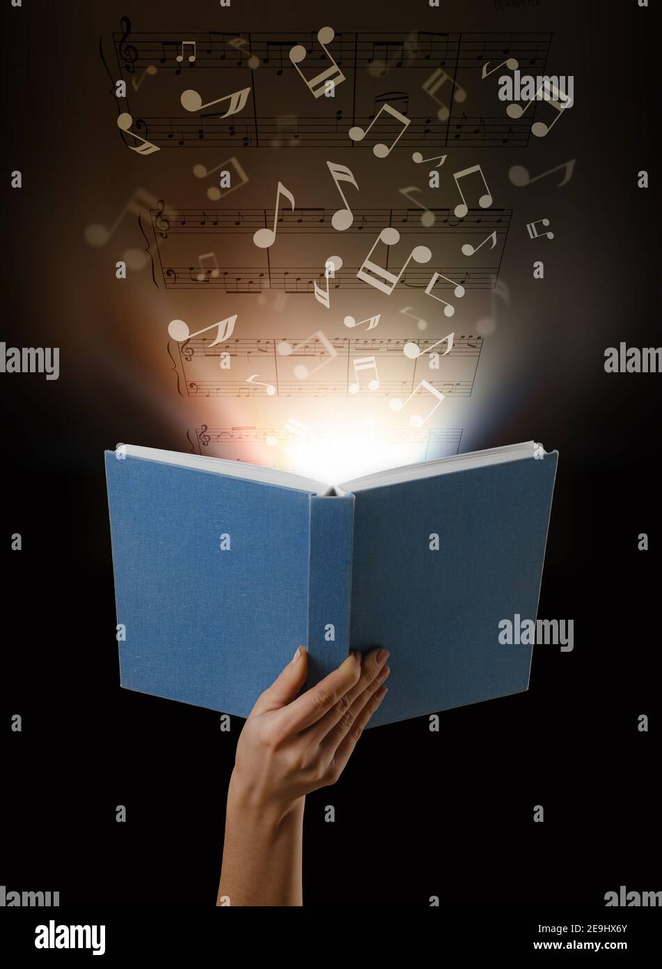 Female hand holding open book with flying music notes on dark ...