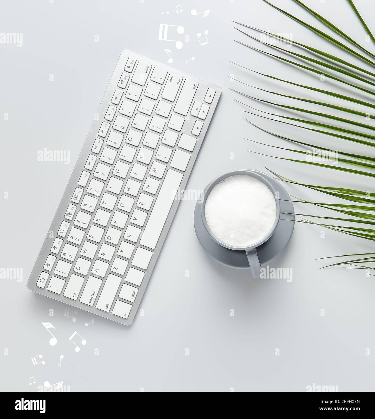 Cup of coffee, PC keyboard and flying music notes on light background ...