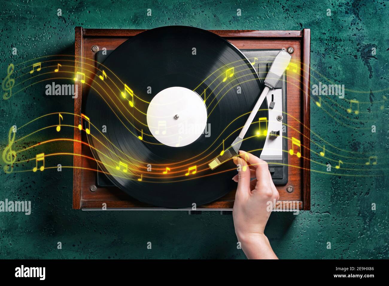 Hand of woman switching on record player with vinyl disc, top view ...