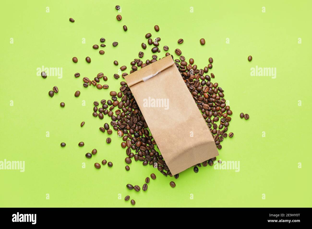 Paper bag with coffee beans on color background Stock Photo - Alamy