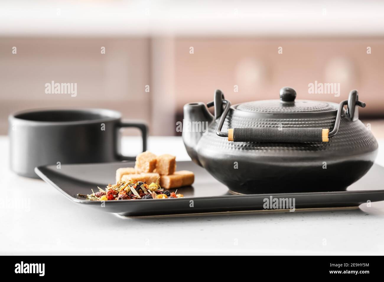 Stylish teapot and dry tea leaves on light table in room Stock Photo ...