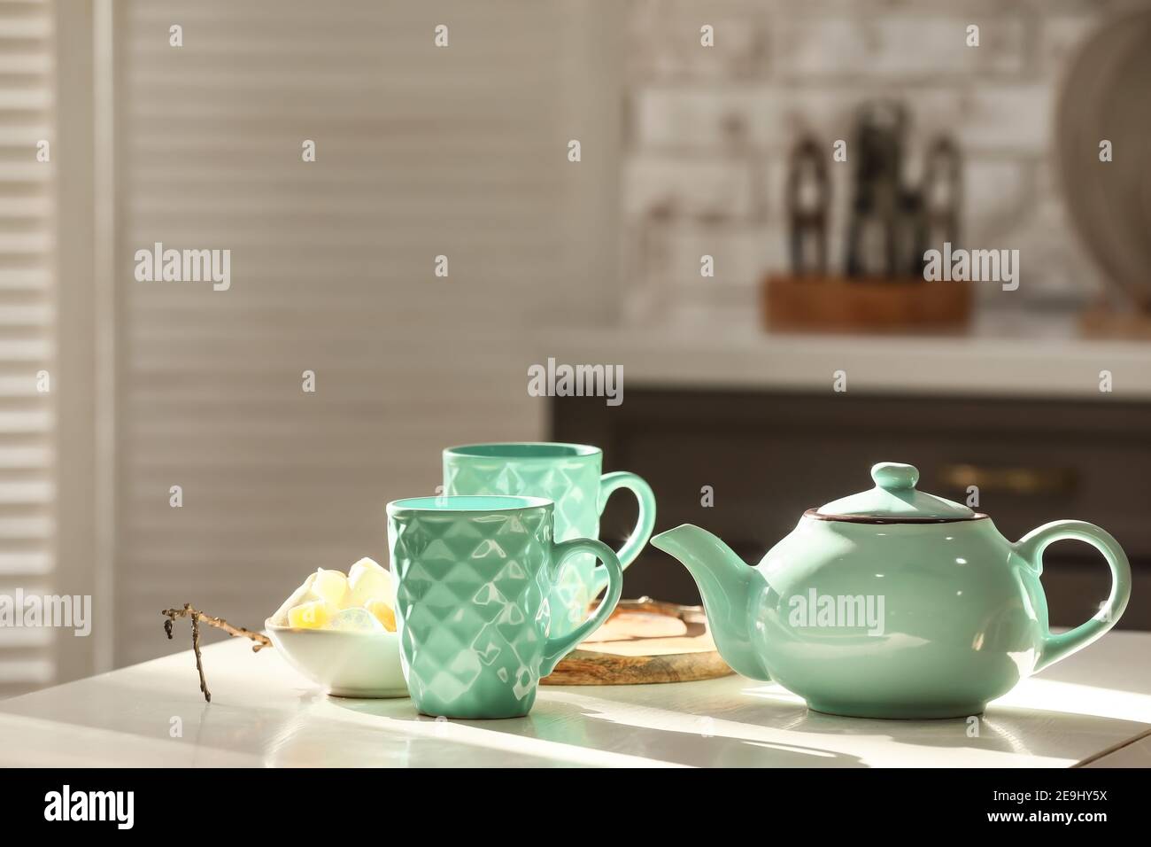 Stylish teapot and cup on light table in room Stock Photo - Alamy