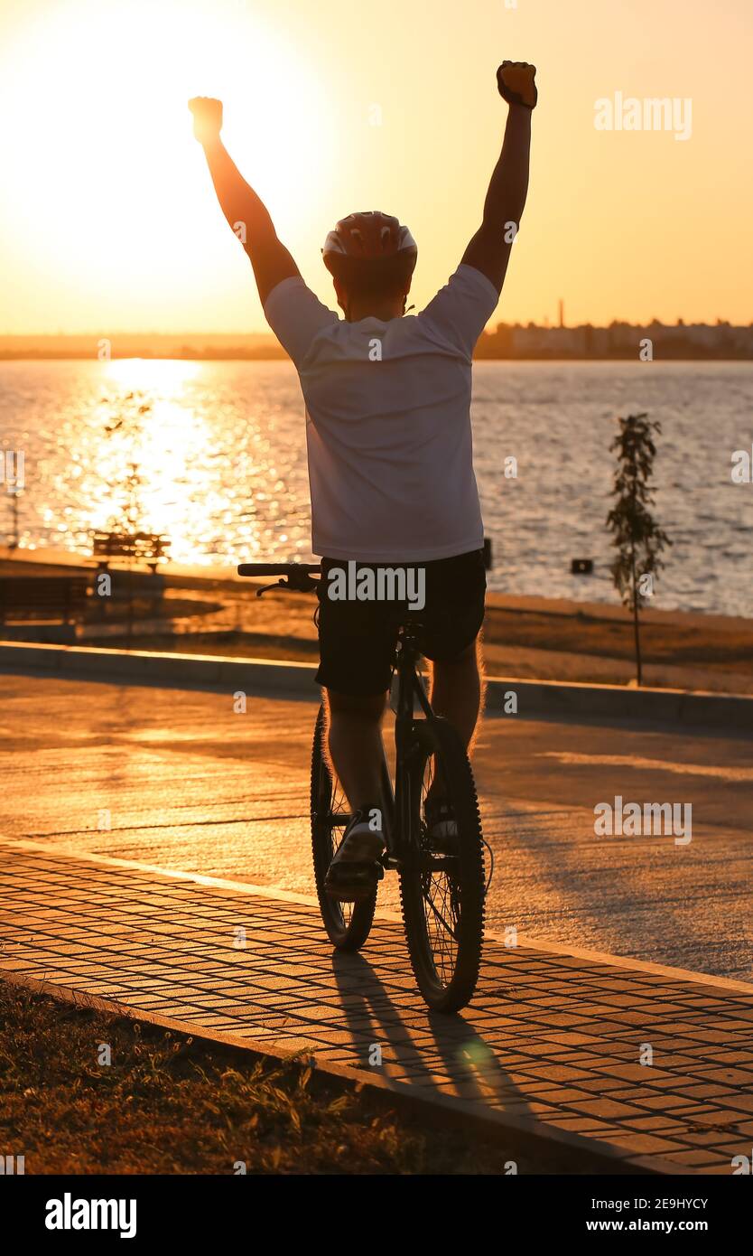 Male cyclist on bicycle raising hands outdoors Stock Photo - Alamy