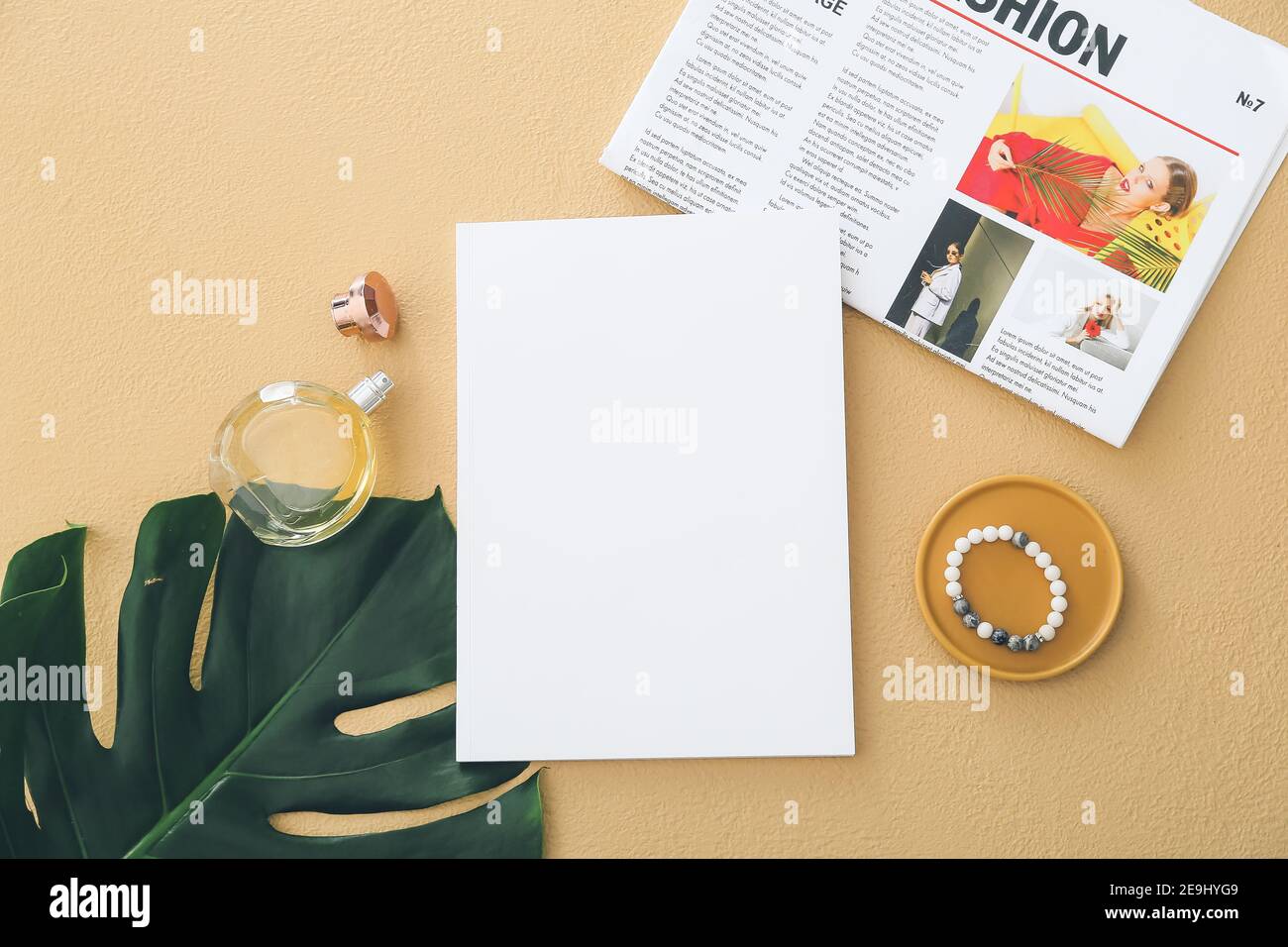 Blank magazine, perfume and newspaper on color background Stock Photo ...