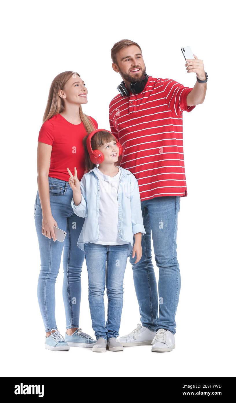 Happy family with mobile phones and headphones taking selfie on white ...