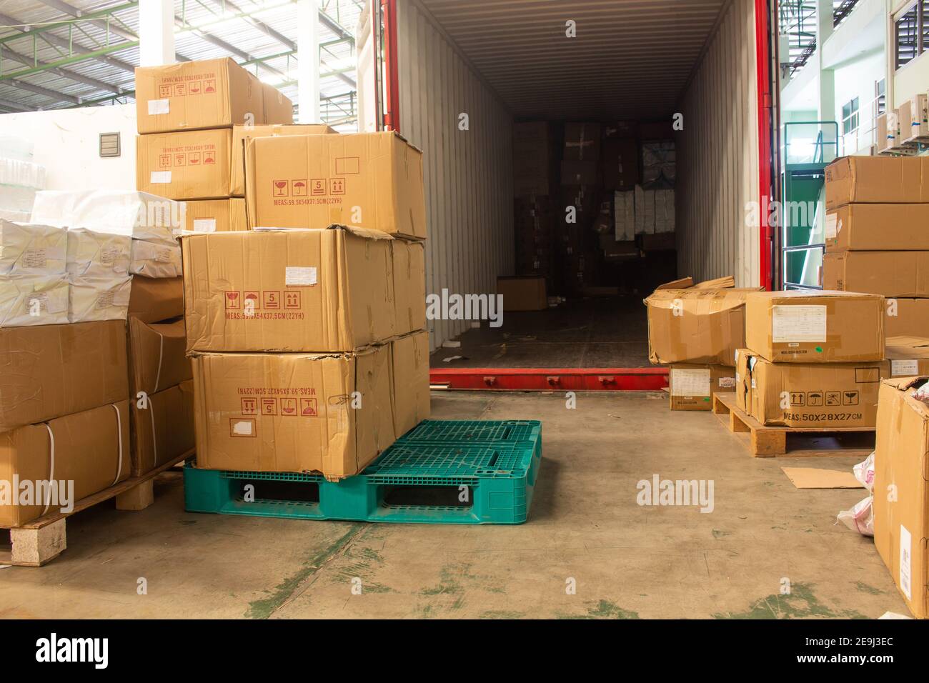 The cartons with loading out of container Stock Photo - Alamy