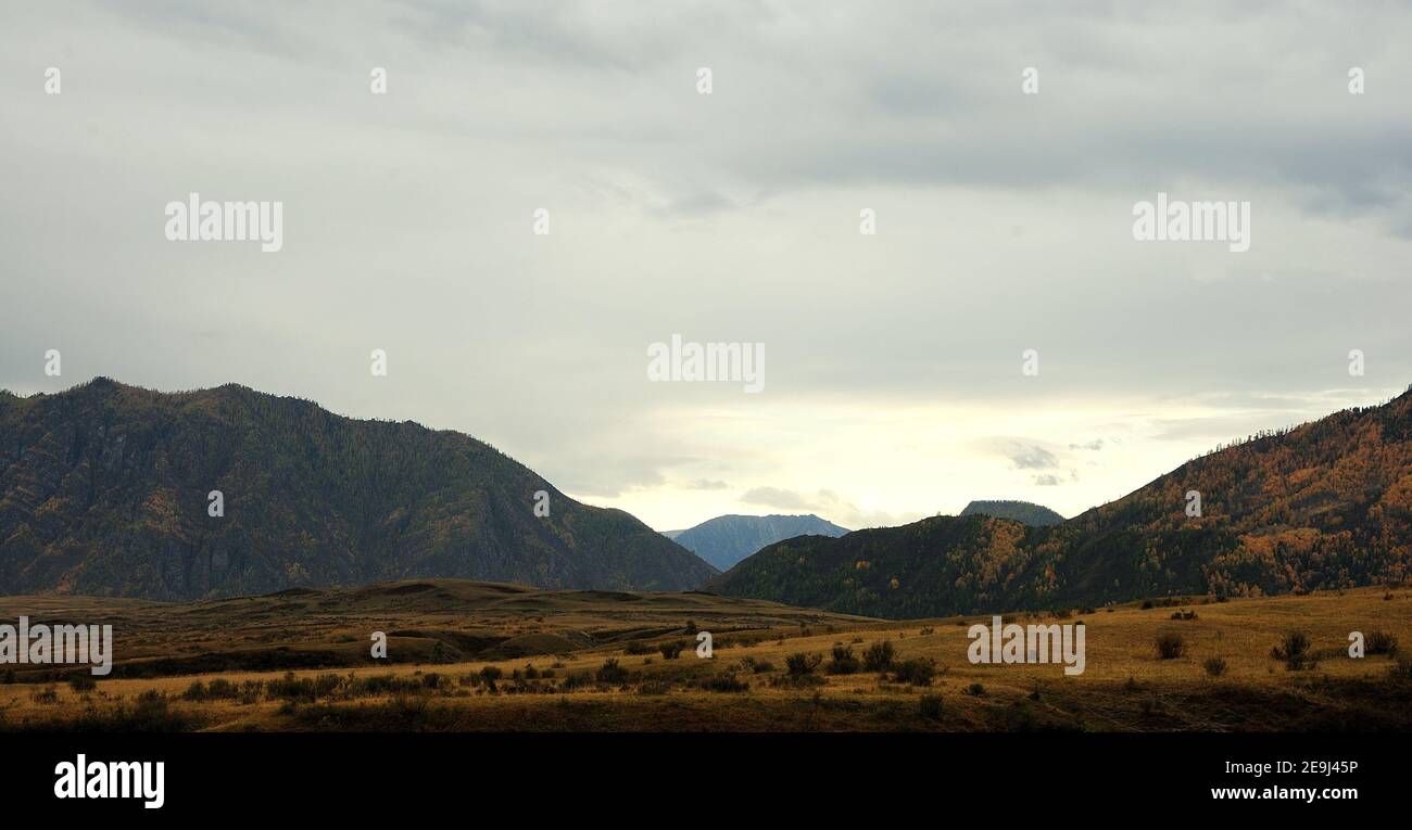 A picturesque hilly valley, stretching in the fall at the foot of high ...