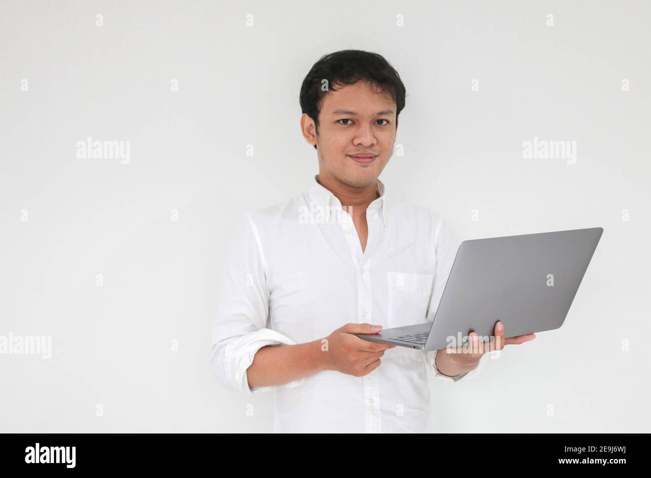 Young asian man is smile and enjoy when working at home with laptop ...